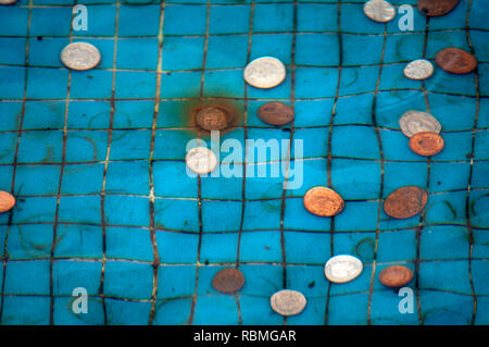 Coins thrown into wishing well Stock Photo - Alamy