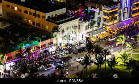 helicopter view over ocean drive, miami, on a busy night with colorful ...