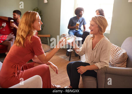 Two Female Friends Making Toast As They Drink Wine At Home Standing By ...