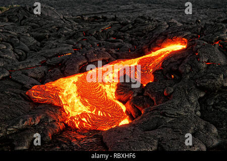Hot magma escapes from an earth column as part of an active lava flow ...