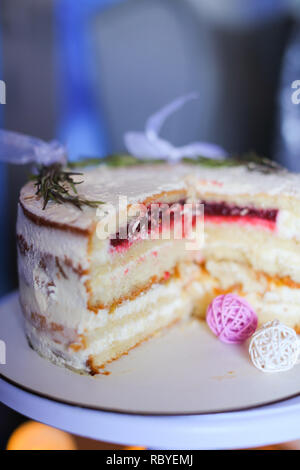A cut of a birthday cake with garland with bright bokeh lights in the ...