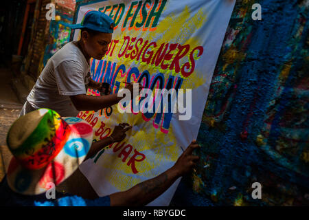 A Colombian sign painter paints letters on a hand-painted promotional ...