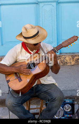 Old Cuban musician playing acoustic guitar solo on a street corner in ...