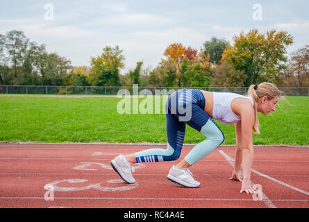 Beautiful female sprinter waiting for the start on a runway Stock Photo ...