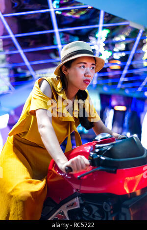 Playing driving game at arcade Stock Photo - Alamy