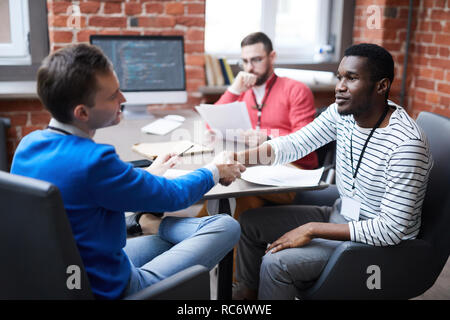 Young Man Coming to terms with a handshake isolated on a white ...