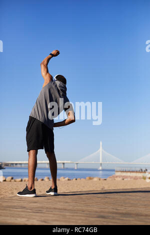 Side rear view of an athlete stretching her foot. Stretching the foot ...