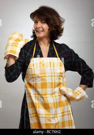 Housewife with apron and cooking gloves over gray background Stock ...