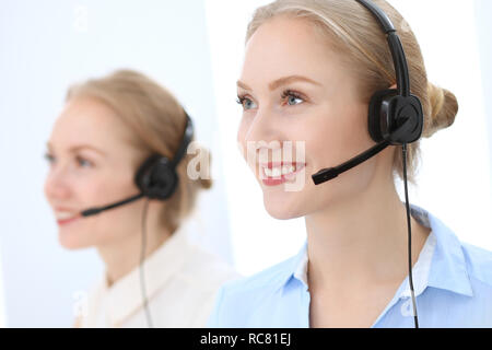 Bright and sunny call center. Group of blonde women in headset at work ...