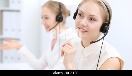 Bright and sunny call center. Group of blonde women in headset at work ...