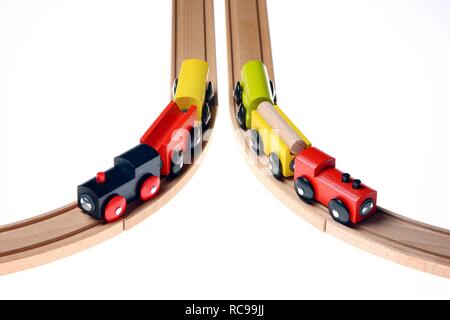 Two toy wooden trains moving in different directions after passing a ...
