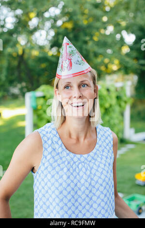 Mature woman in party hat with Birthday gift on orange background Stock ...