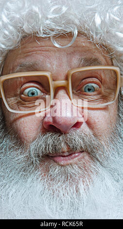 Surprised man in Santa costume and with watch on color background with ...