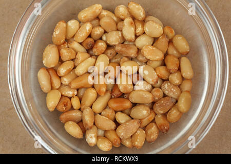 Pine nuts in a glass bowl closeup on white Stock Photo - Alamy
