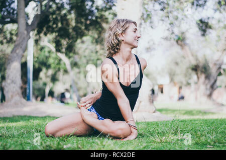 Pretty woman doing yoga exercises in the park Stock Photo - Alamy