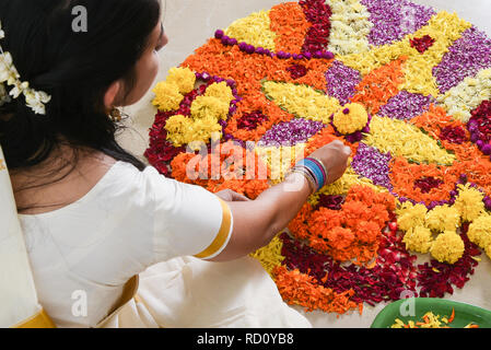 Woman lighting a lamp for a traditional Vishu kani (Vishukani) setting ...