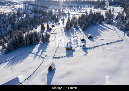Snow covered remote village, homestead in the mountains. Aerial drone ...