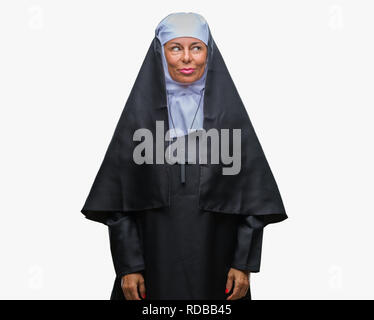Middle age senior christian catholic nun woman over isolated background ...