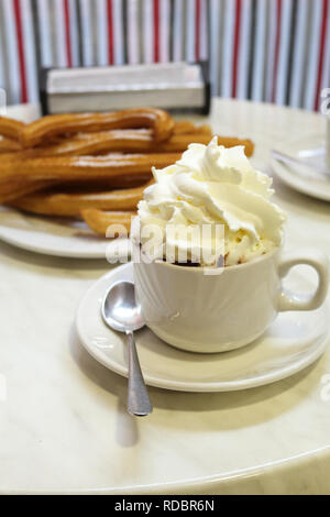 A typical spanish merienda, light meal: a cup of hot chocolate with ...
