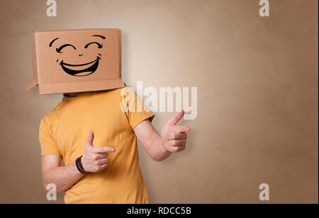 Young man with happy face illustrated cardboard box on his head Stock ...