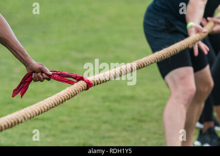 A hand holds a bandana attached to a thick rope before the start of a ...
