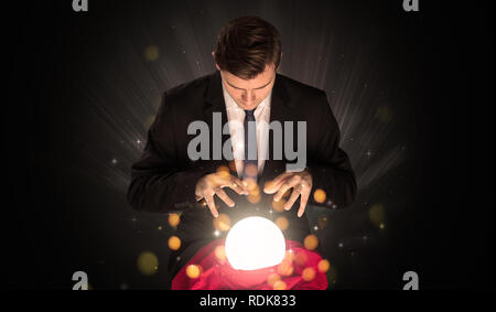 Gorgeous businessman sitting with sparkling magic ball in his lap Stock ...