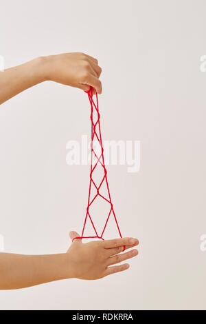 Japanese woman playing with red string Stock Photo - Alamy