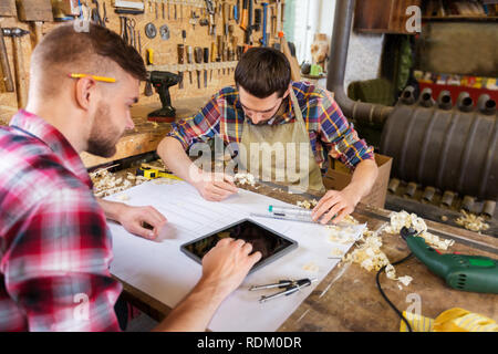 carpenters with tablet and blueprint at workshop Stock Photo - Alamy