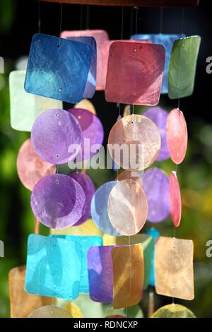 Colourful wind chime made of coloured plastic, hanging outside on a ...