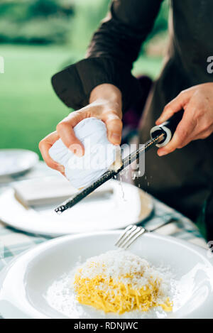 Grating cheese on a plate of spaghetti Stock Photo - Alamy