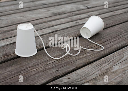 Two cups connected with a string Stock Photo - Alamy