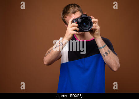 Portrait of photographer man using DSLR camera in studio Stock Photo ...