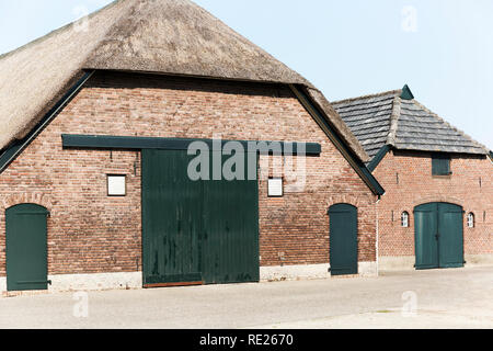 Traditional Dutch farm with thatched roof and an ancient wooden wagon ...