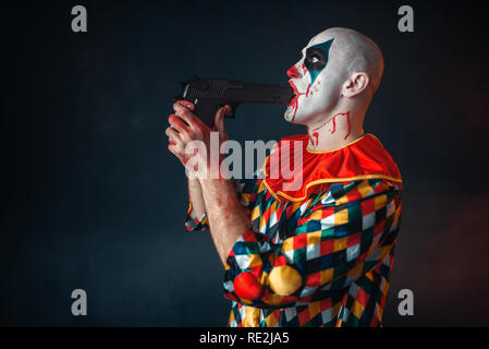 Evil clown with gun in dark room Stock Photo - Alamy