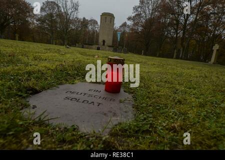 A candle remains lit on top of a grave marker of an unknown German ...