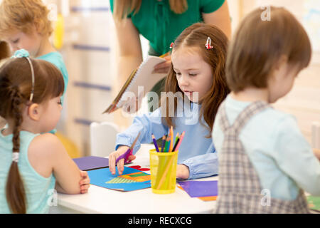 Kids working with paper on table in kindergarten Stock Photo: 106683642 ...