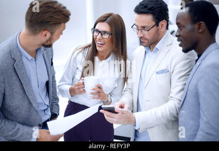 employees discuss something standing in the office Stock Photo - Alamy