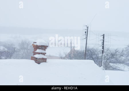 Chimney in red bricks and antennas with white snow on rural roof Stock ...
