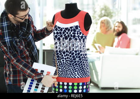 fashion designer holding tissue sample and writing in notebook near ...