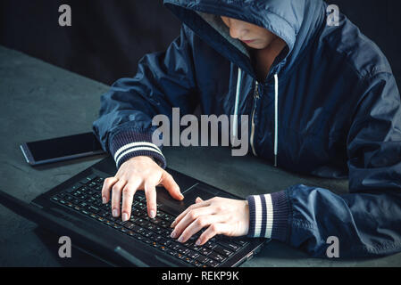 Hacker teen programmer uses a laptop to hack the system. Stealing ...