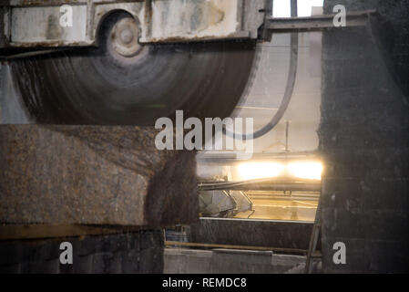 Granite processing in manufacturing. Cutting granite slab with a ...