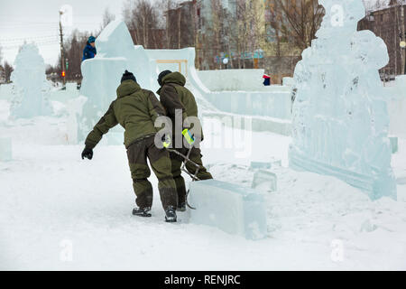 Two workers are pulling an ice block around the ice camp assembly site ...