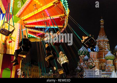 People ride a chain carousel at the Red Square with the St. Basil's in ...