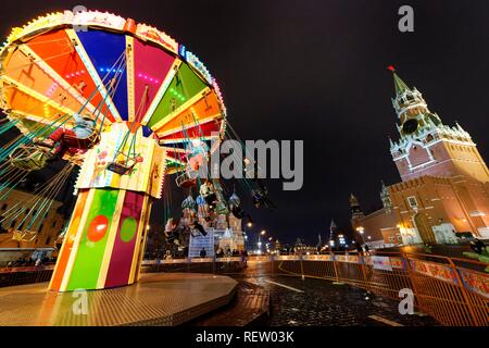 People ride a chain carousel at the Red Square with the St. Basil's in ...