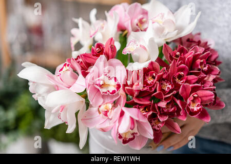 Japanese Wanda Orchid in metal vases in womens hands. Bunch pale pink ...