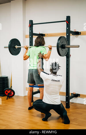 Black man coach training barbell with his patient in gym Stock Photo ...