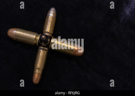 Pistol bullets gathered together in the shape of a cross. War concept ...