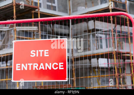 personnel entrance to building site with warning site traffic sign and ...