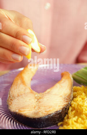 Female hand squeezing lemon on marinated steak in glass dish Stock ...