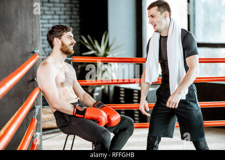 Boxing trainer giving instructions during a break motivating a boxer ...